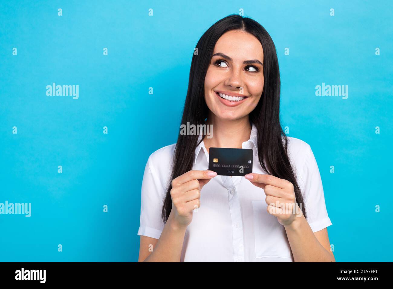 Photo of shiny dreamy girl dressed white shirt rising bank card looking ...