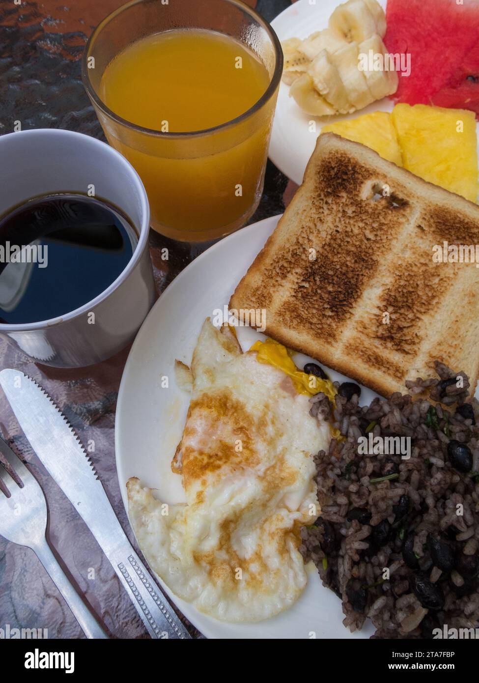 Breakfast with fried eggs, beans, coffee, juice and fruits in a hostel ...