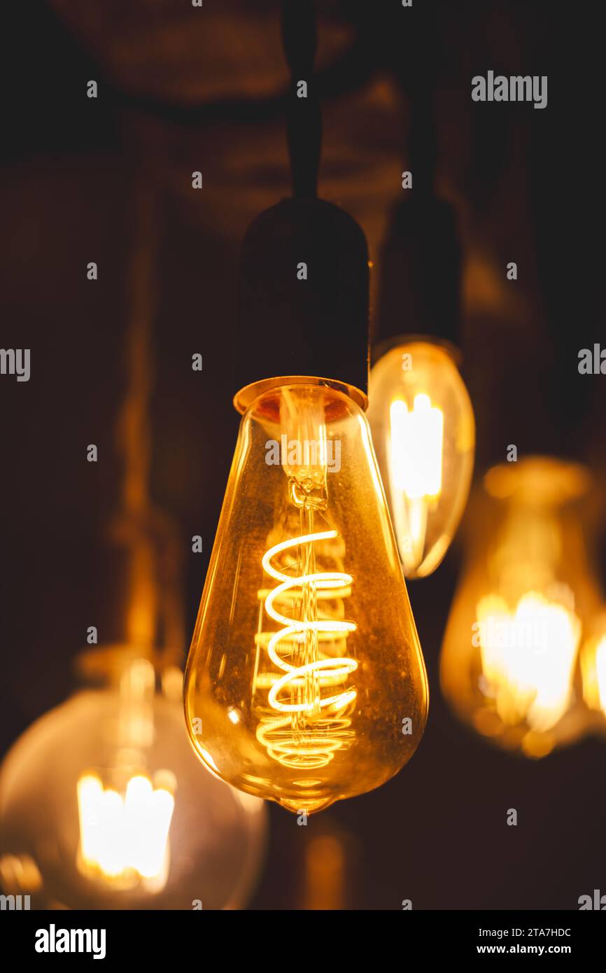 Spiral Retro LED light bulbs hanging on a dark background in interior ...