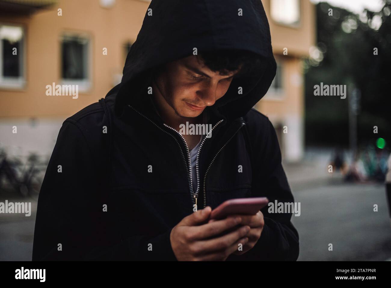 Teenage boy text messaging through smart phone Stock Photo - Alamy