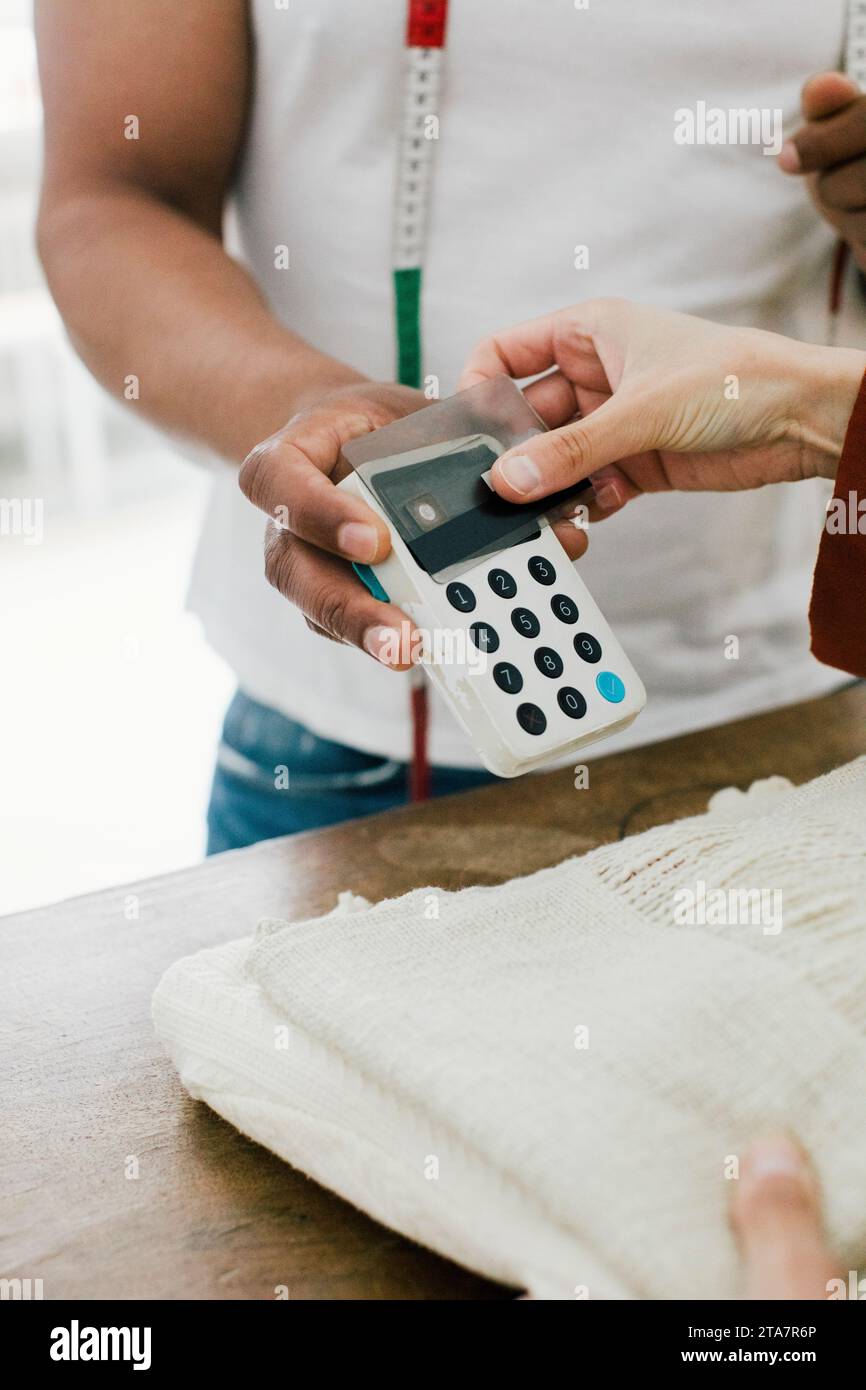 Hand of customer paying through credit card at store Stock Photo - Alamy
