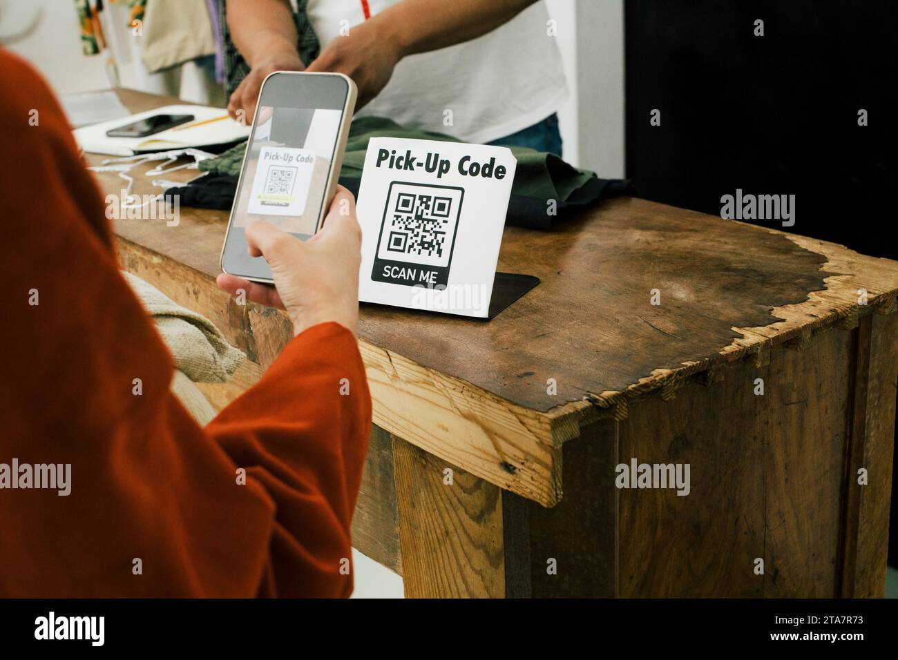 Female customer scanning bar code through smart phone while paying at ...