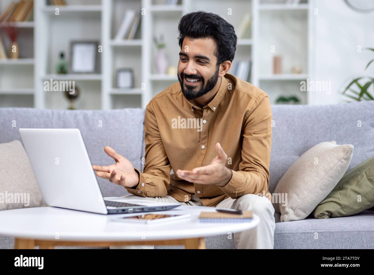 Happy handsome young indian man freelancer talking by online video call ...