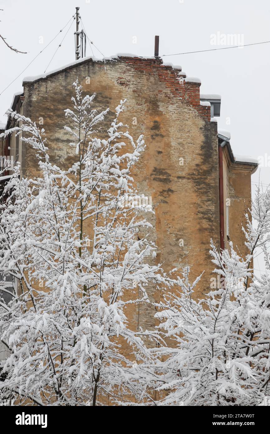 Facade of a residential building in the suburbs during a snowfall. The ...