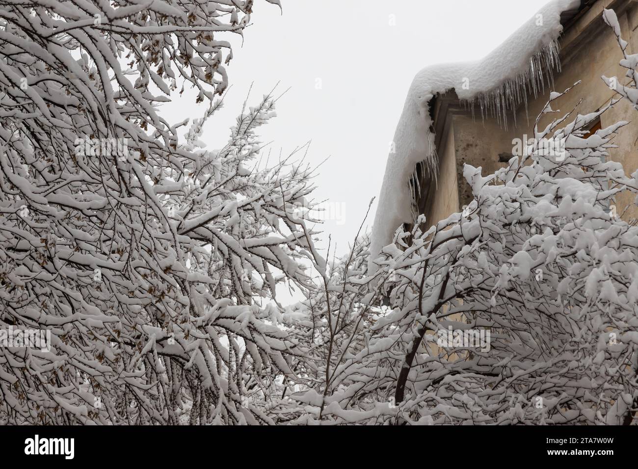 Facade of a residential building in the suburbs during a snowfall. The ...