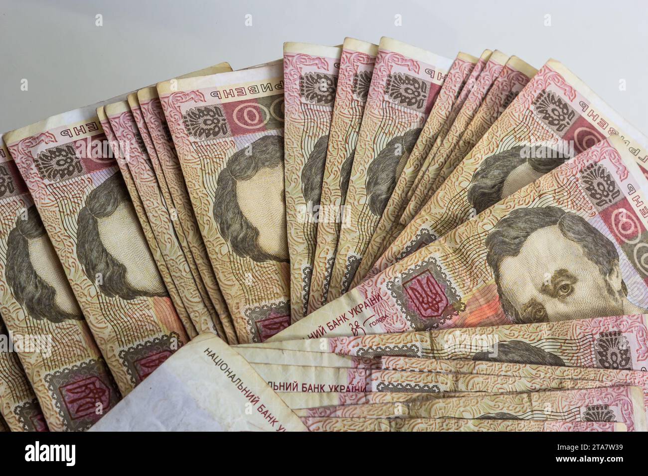 Ukrainian paper money is laid out on a blue background. 100 hryvnia ...