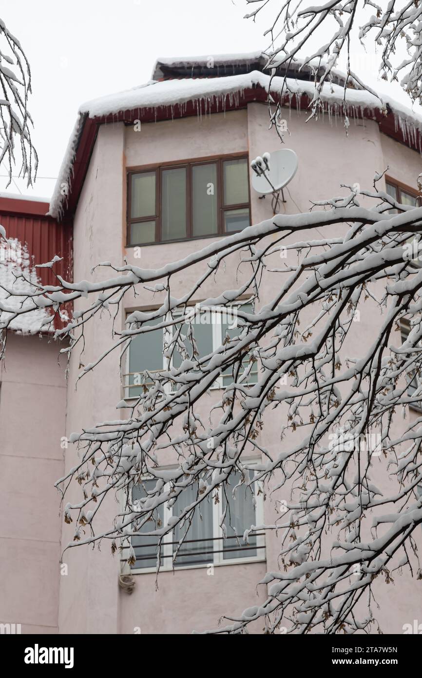 Facade of a residential building in the suburbs during a snowfall. The ...