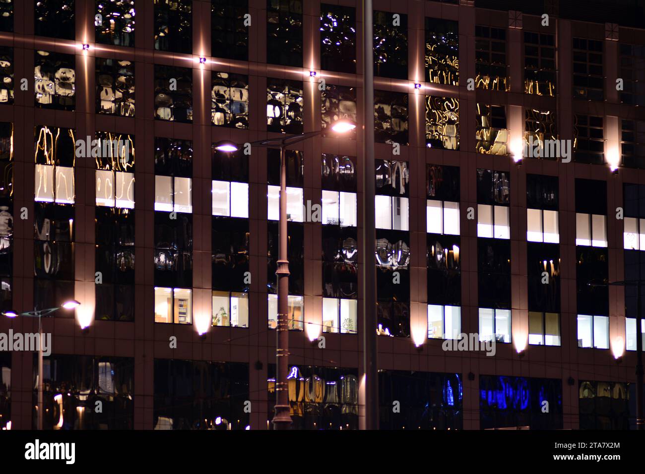 The glass facades of a modern skyscrapers at night. Modern glass office ...