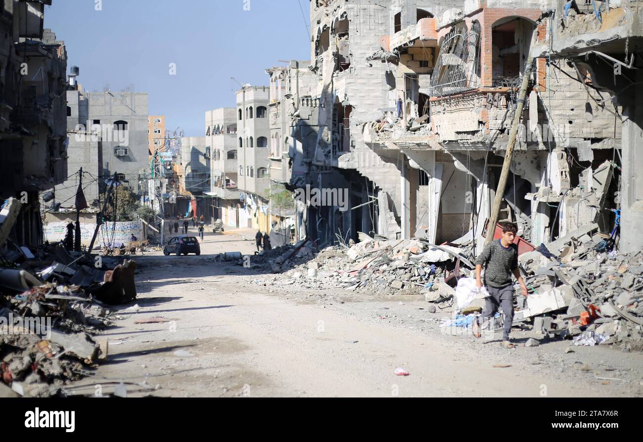 Palestinians walk among the rubble in the residential area Jabalia camp ...