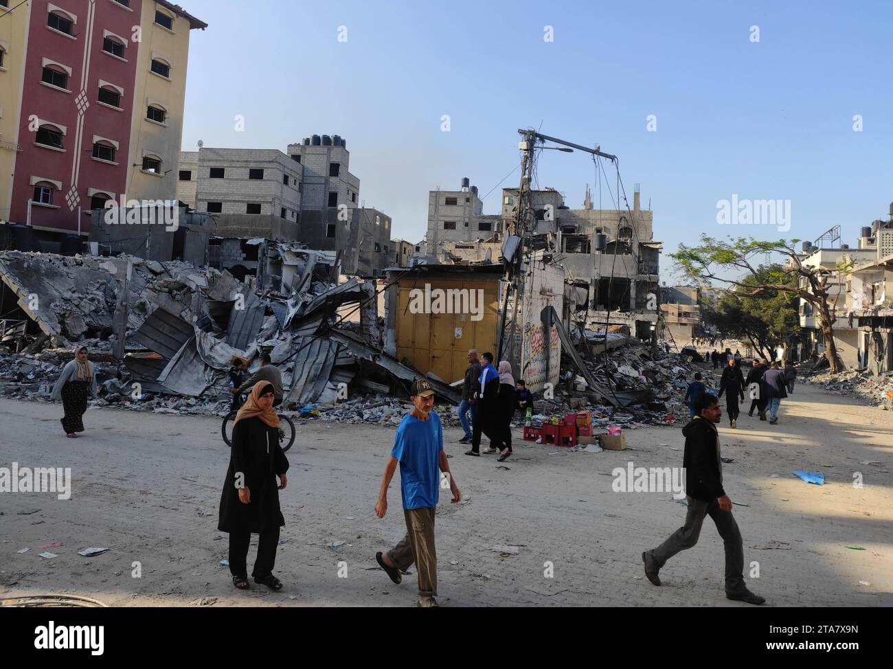 Palestinians walk among the rubble in the residential area Jabalia camp ...