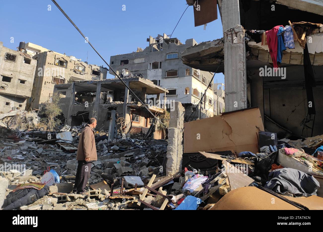 Palestinians walk among the rubble in the residential area Jabalia camp ...