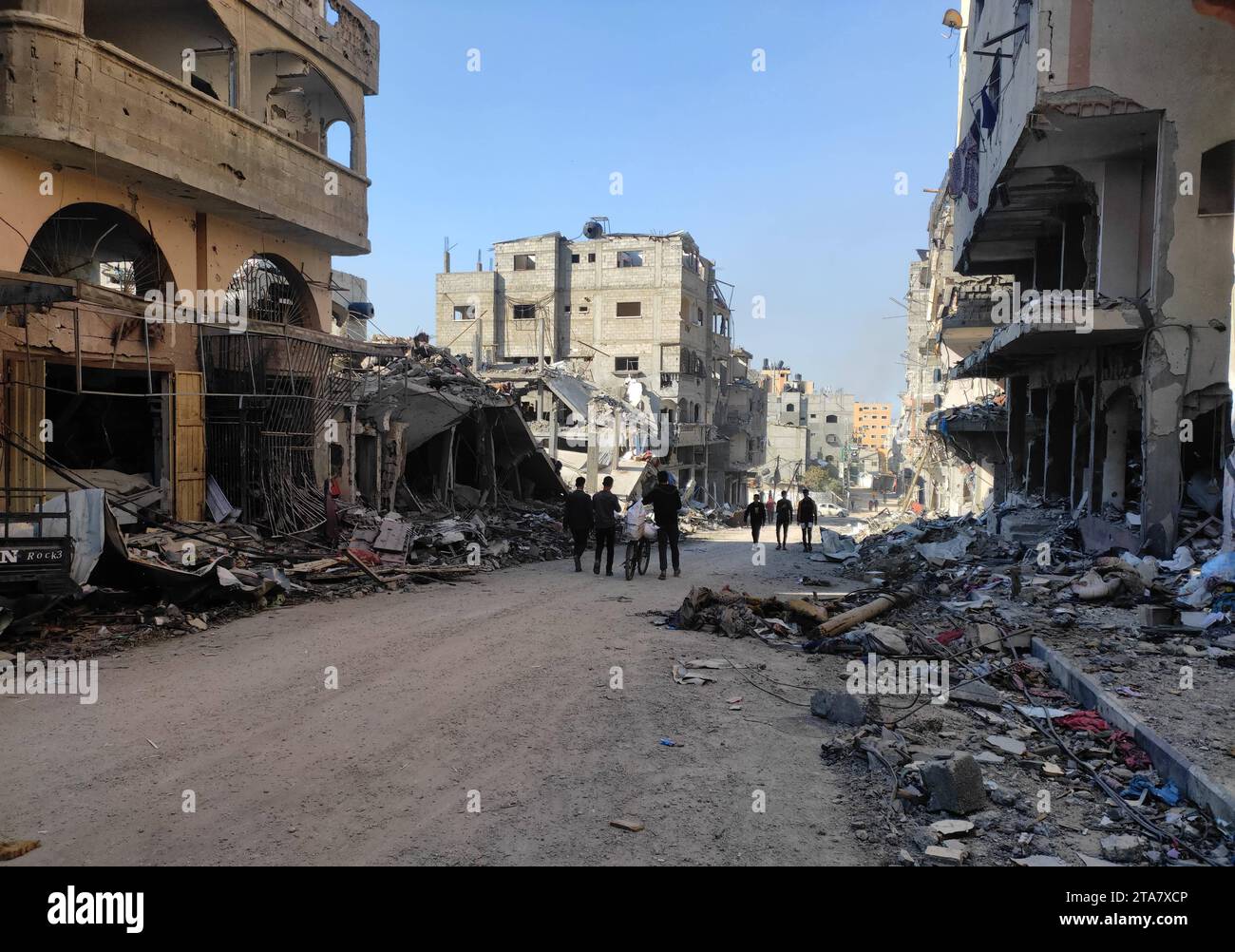 Palestinians walk among the rubble in the residential area Jabalia camp ...