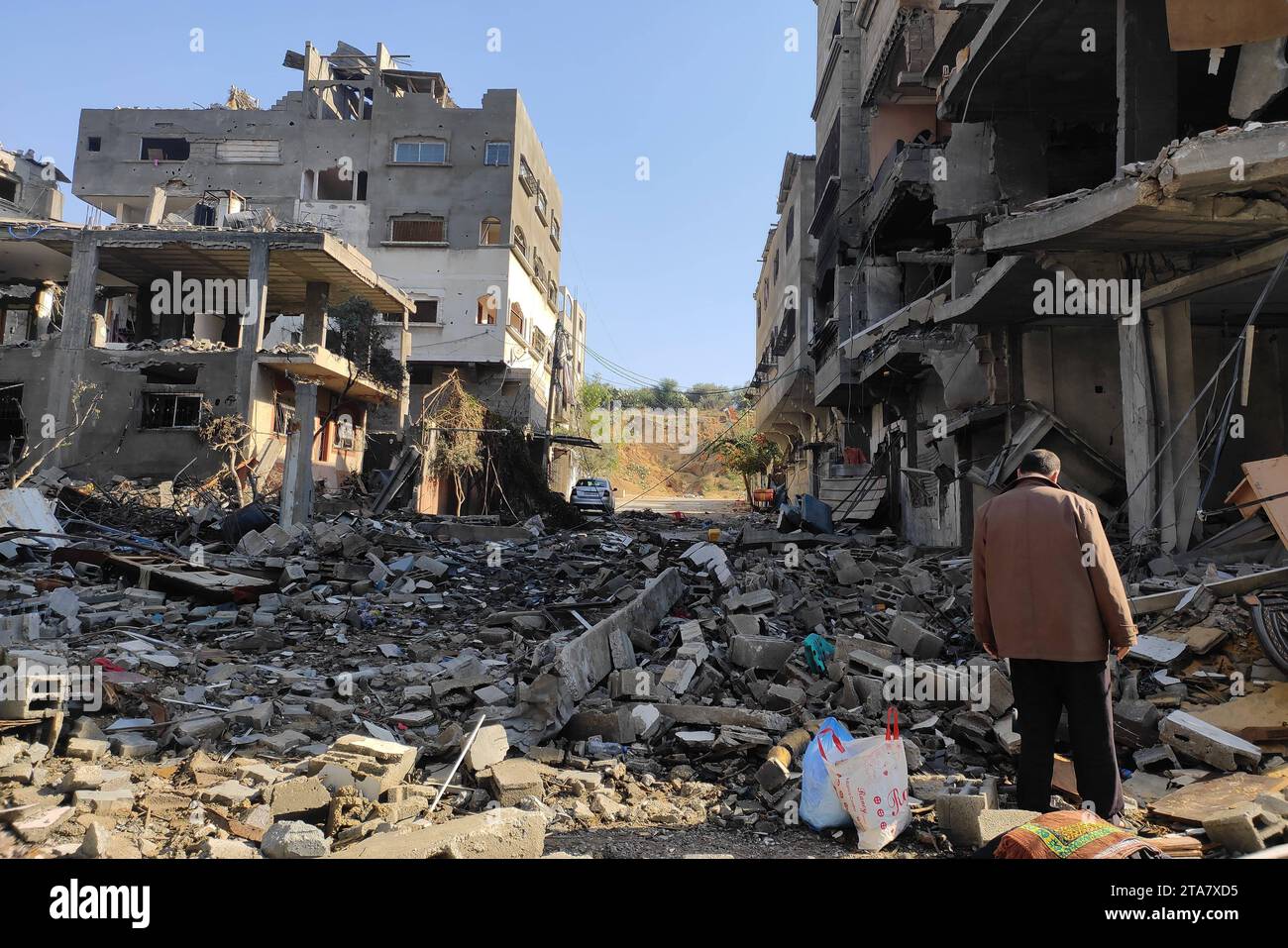 Palestinians walk among the rubble in the residential area Jabalia camp ...