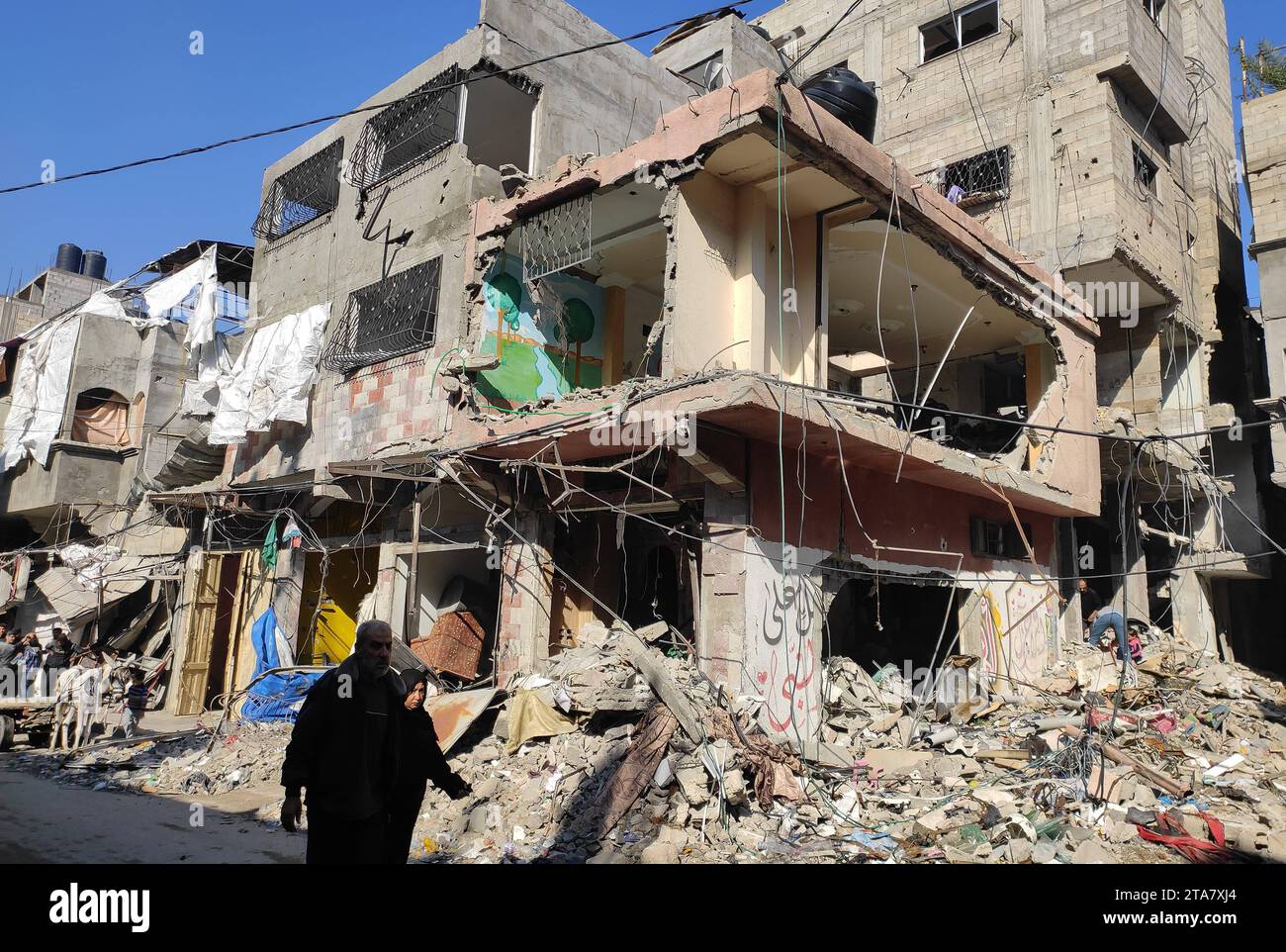 Palestinians walk among the rubble in the residential area Jabalia camp ...