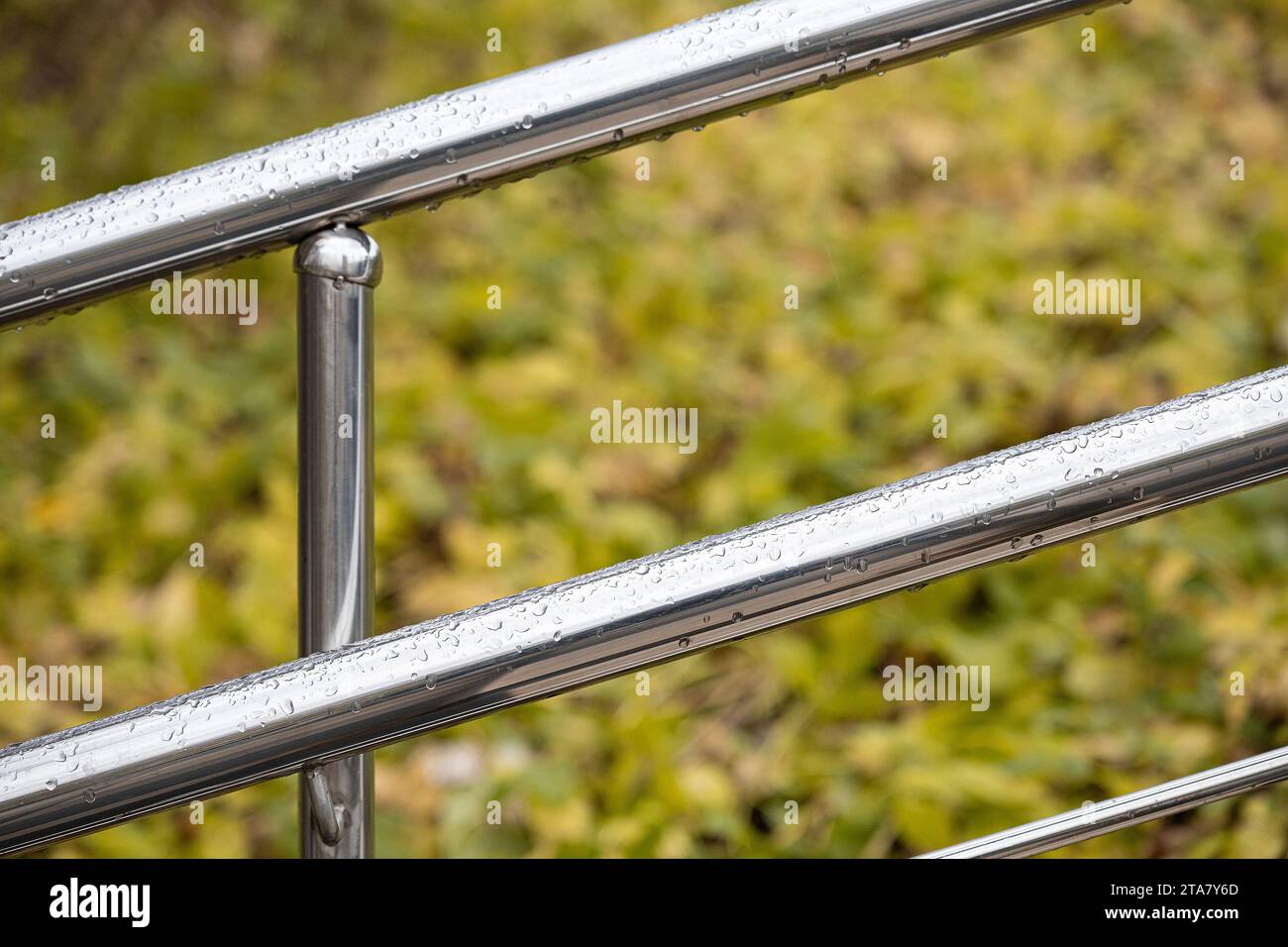 metal handrail with raindrops, shot with shallow depth of field. metal ...