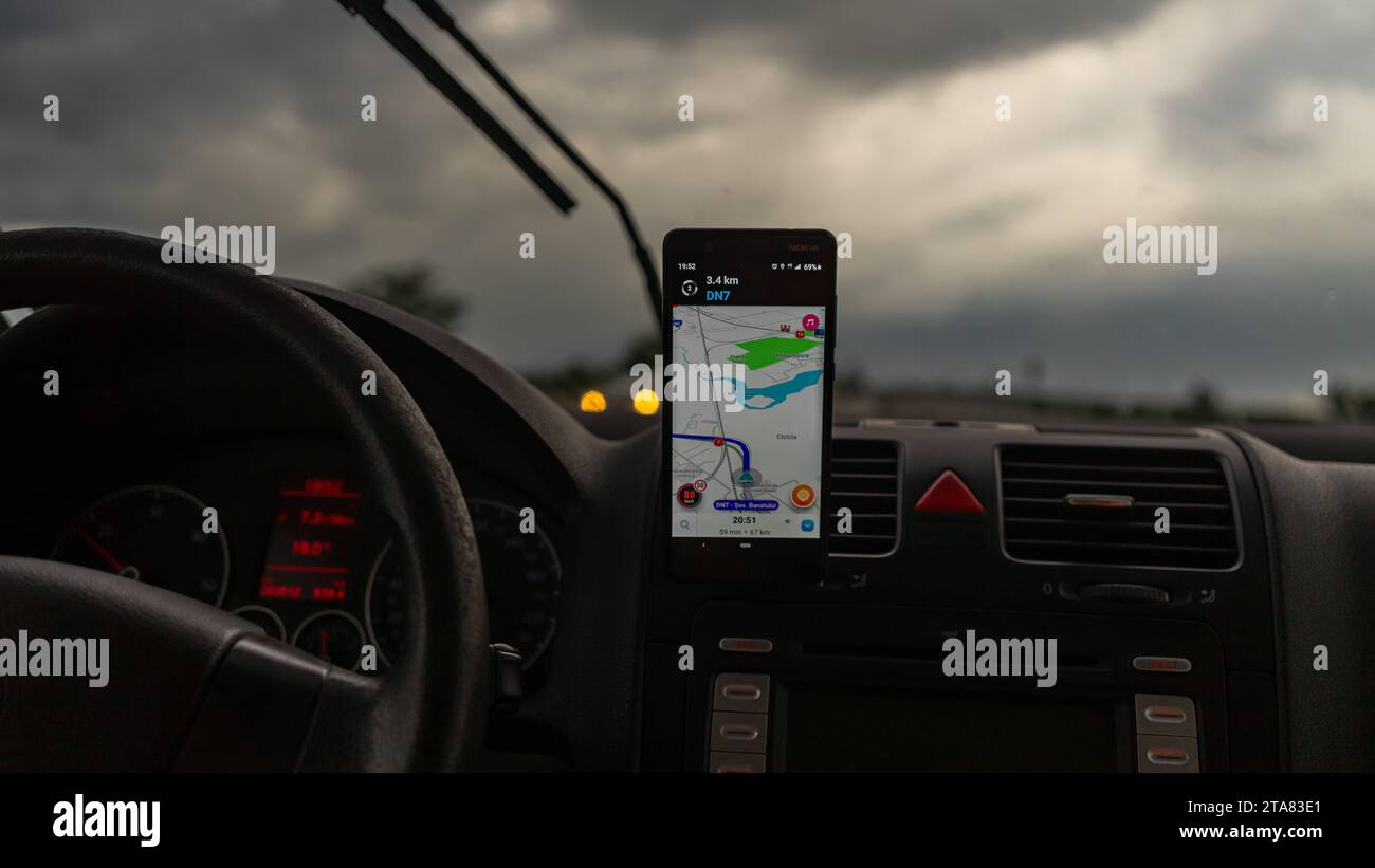 Smartphone showing Waze maps to show the way thru the city. Driver ...