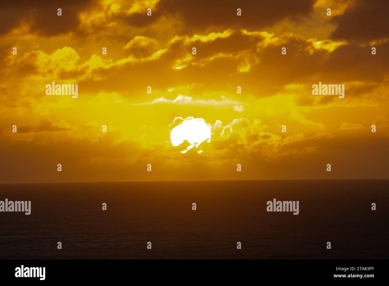 bright sunset at a beach with the very bright sun setting Stock Photo ...