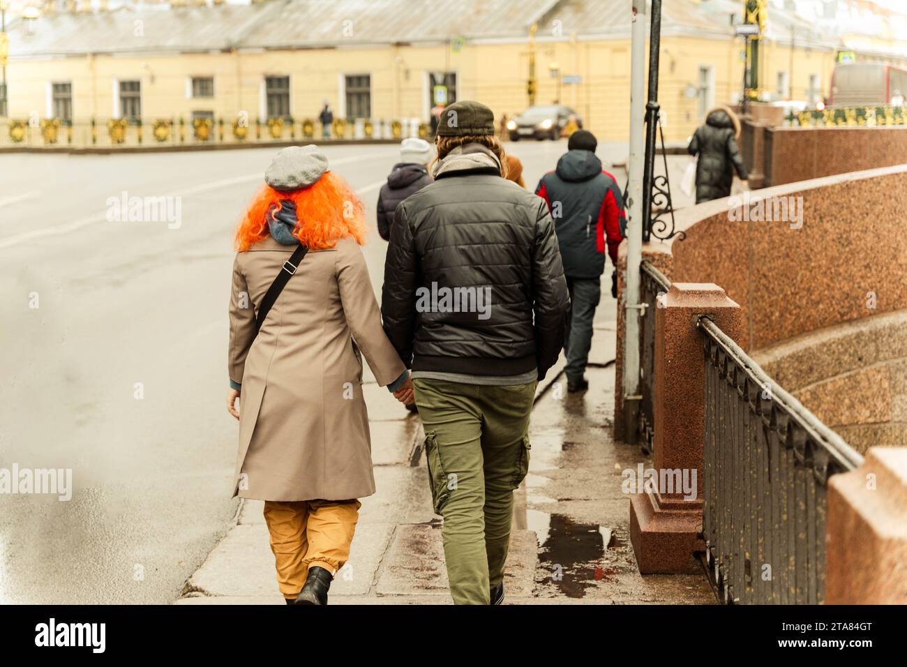 Charming Red-Haired WA charming red-haired woman walks hand in hand ...