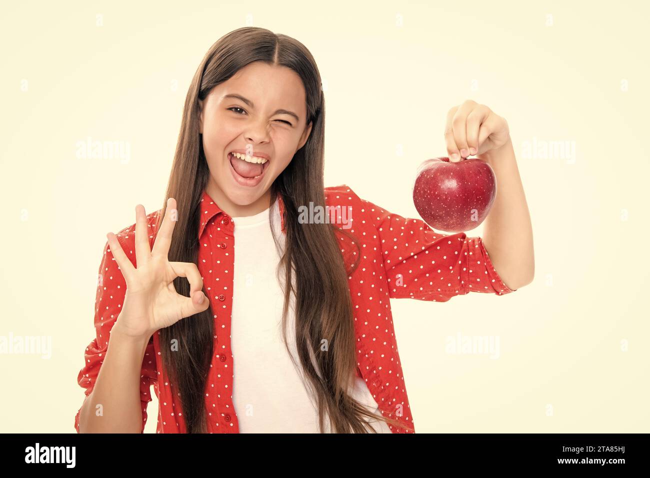 Teenager child girl biting tasty green apple. Portrait of emotional ...