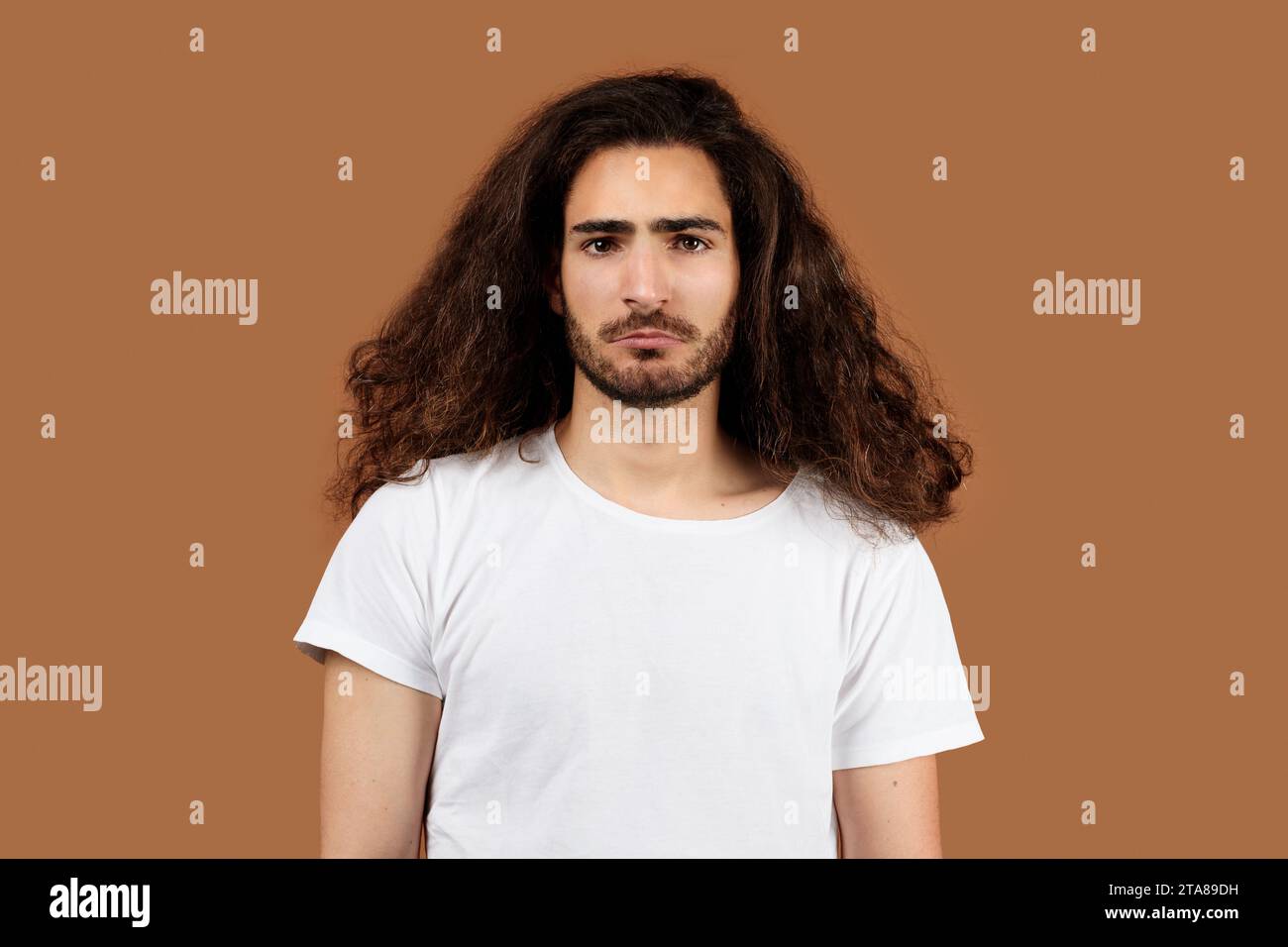 Studio Portrait Of Sad Arabic Guy With Long Curly Hair Stock Photo - Alamy