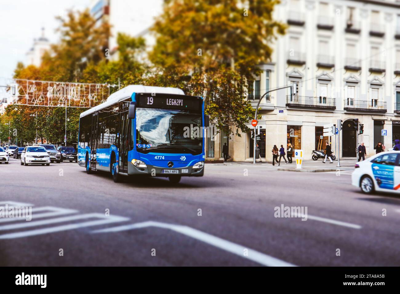 Public transportation traffic Blue bus number 19 Legazpi, white taxi ...
