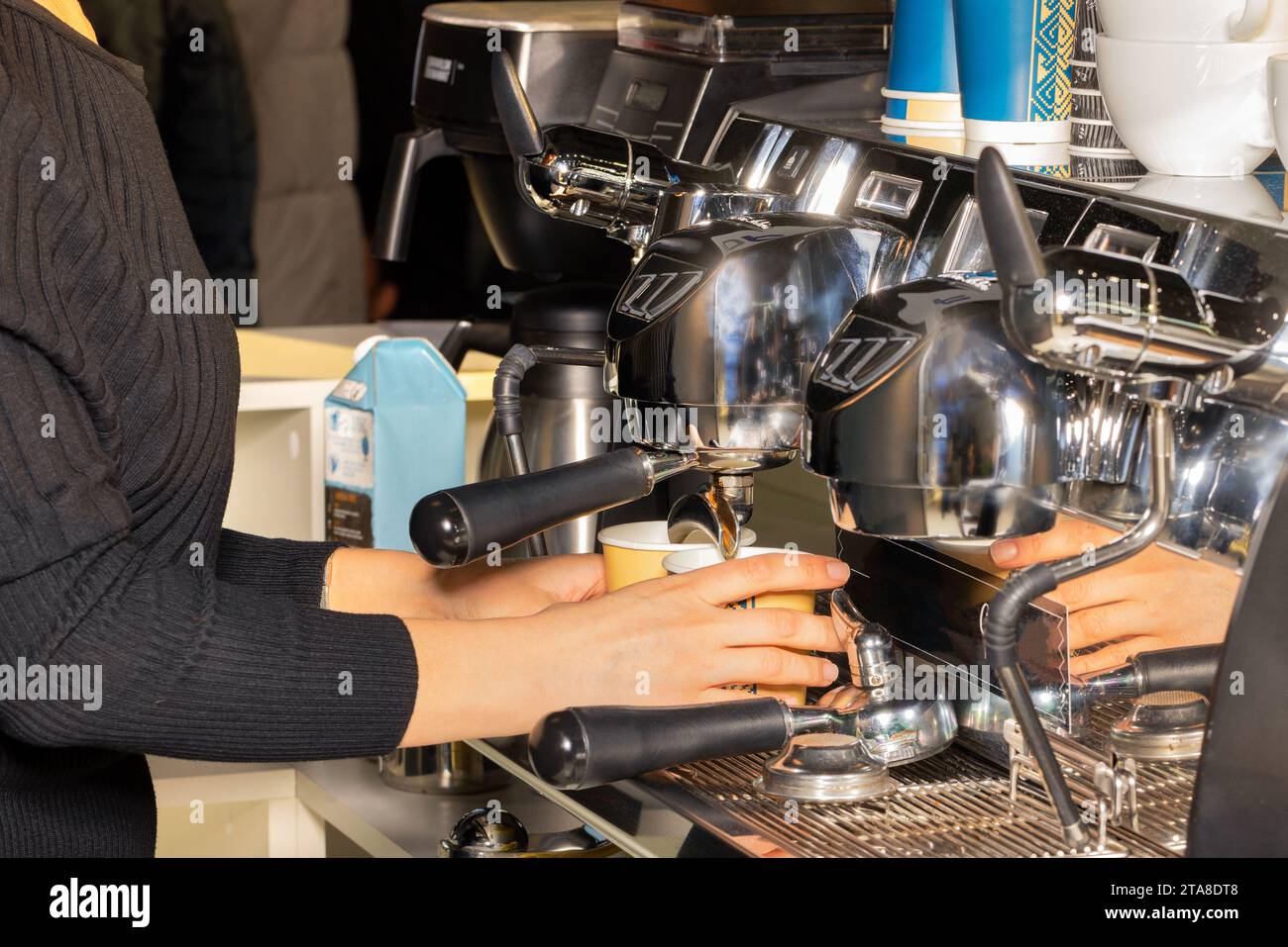 The process of preparing espresso in a coffee machine, the barista pours the drink into two ...