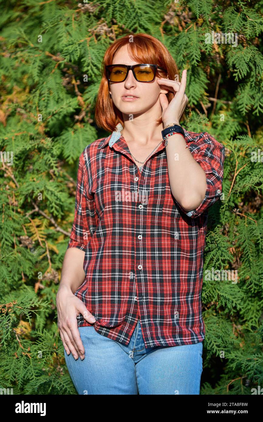 A redhead woman poses gracefully in the warm glow of an autumn sunse ...