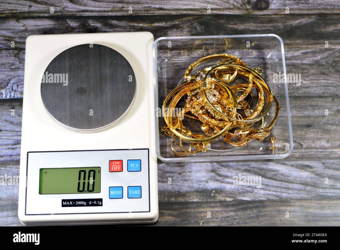 Pile stack of gold and a digital accurate scale in grams, bracelets ...