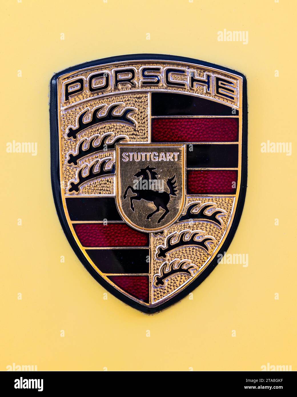 A Porsche crest on the hood of a 1999 pastel yellow Porsche 911 Stock ...