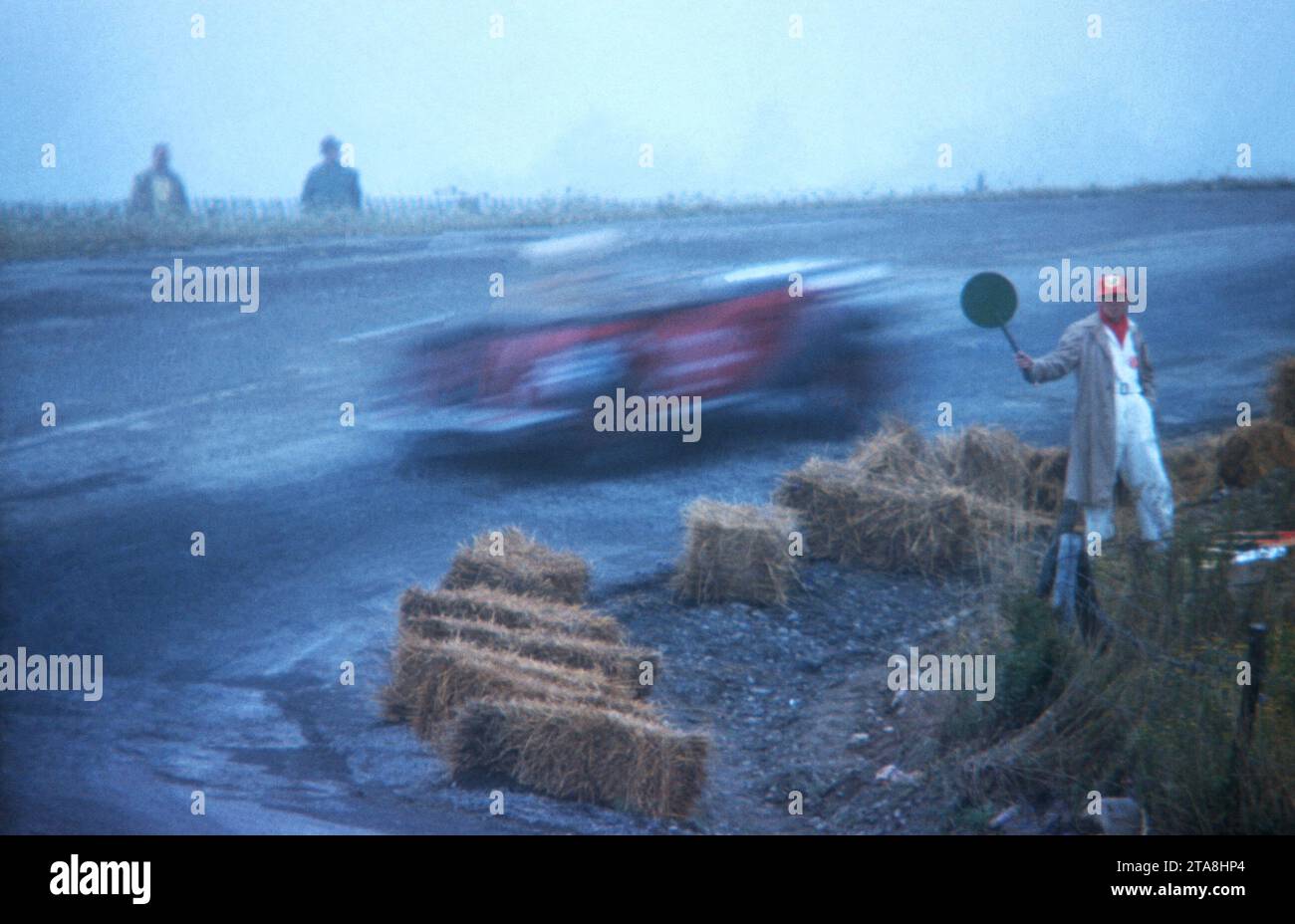 1955: General view of a car racing around hay stacks along a course ...