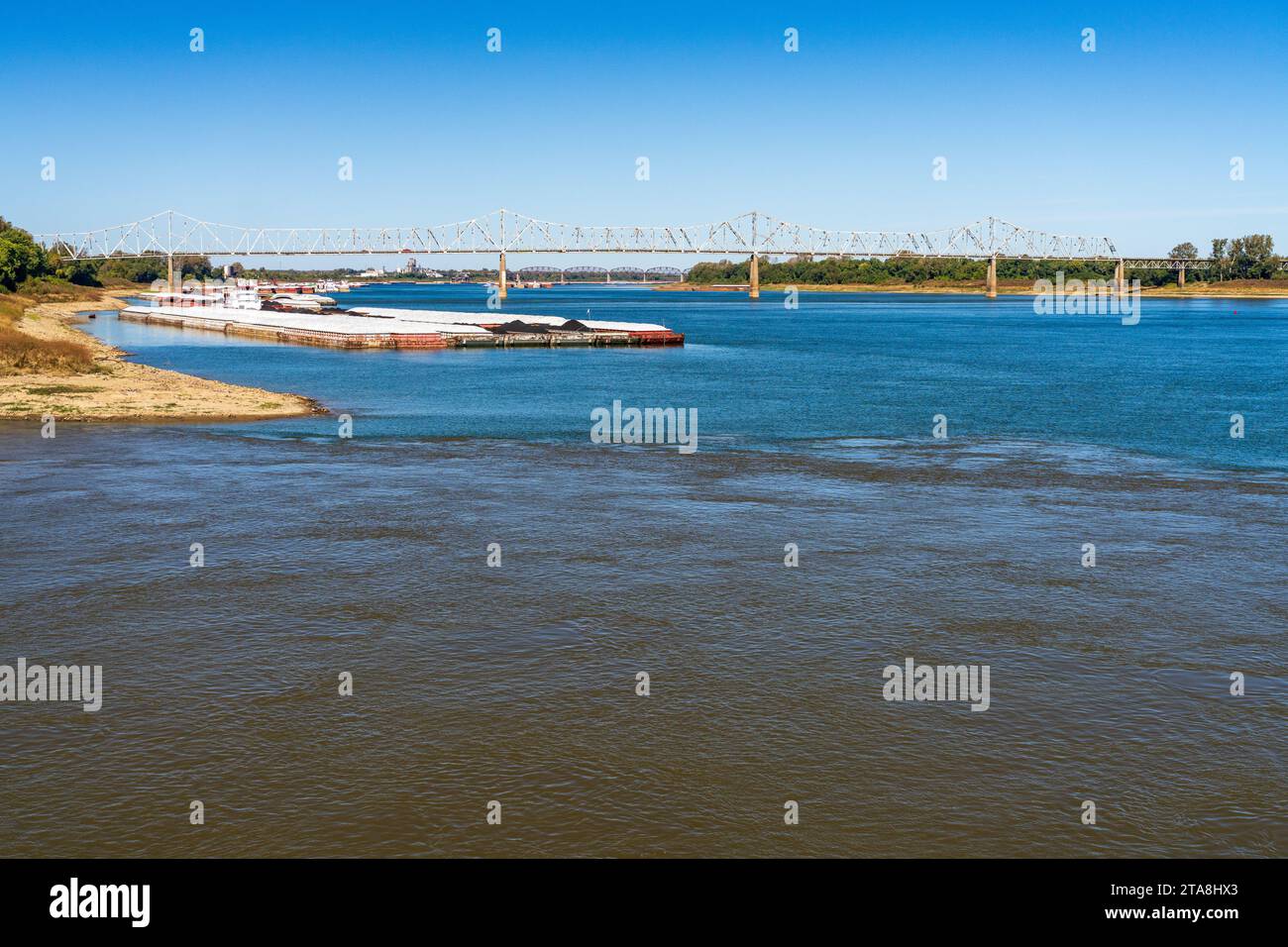 Barges wait at the confluence of the blue Ohio river and brown ...