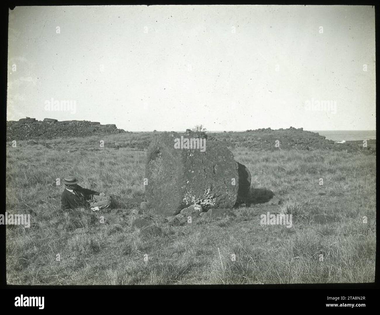 View of a large round stone used as part of a moai, with a White man ...