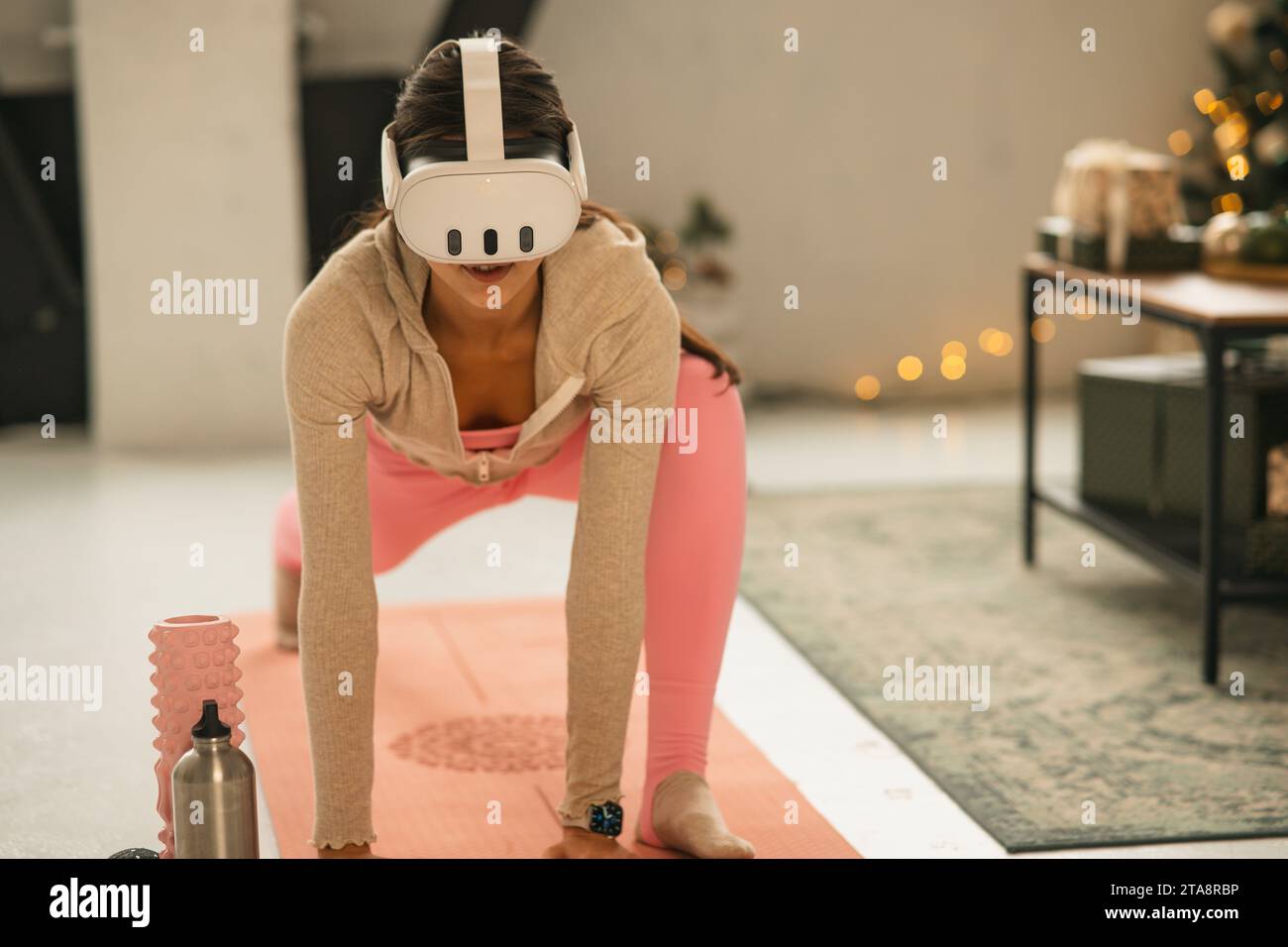 A beautiful young woman in athletic wear stretching with a virtual ...