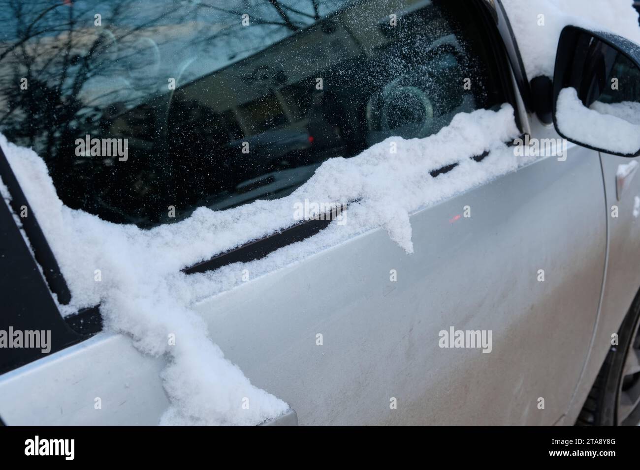 A car parked in the snow, its window covered with a thick layer of snow ...