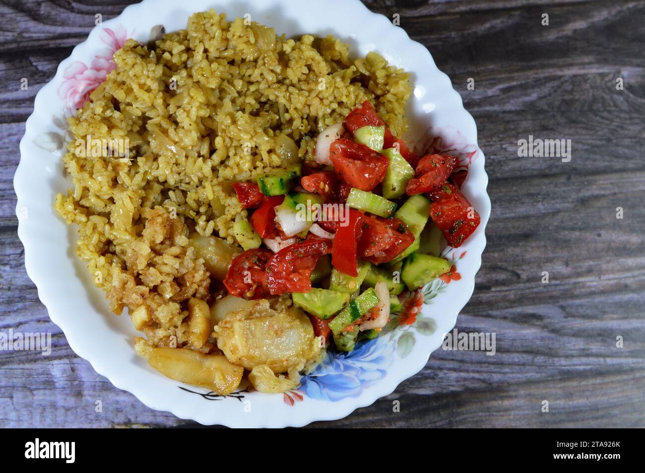 Egyptian rice cooked on hot steam, green salad and fried squid, a ...