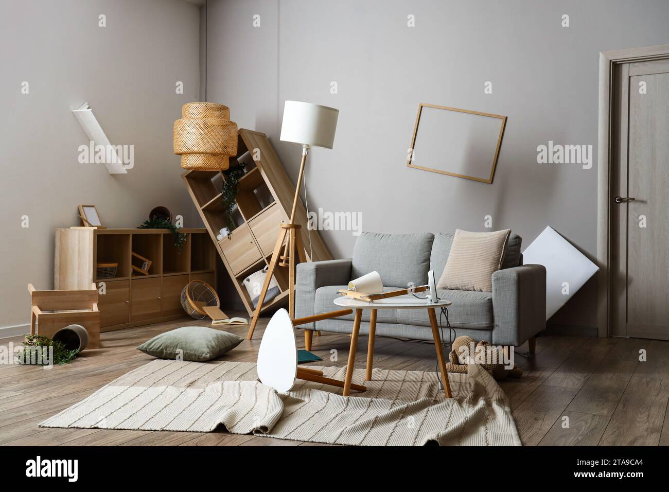 Sofa with tables and shelving units in messy living room Stock Photo ...
