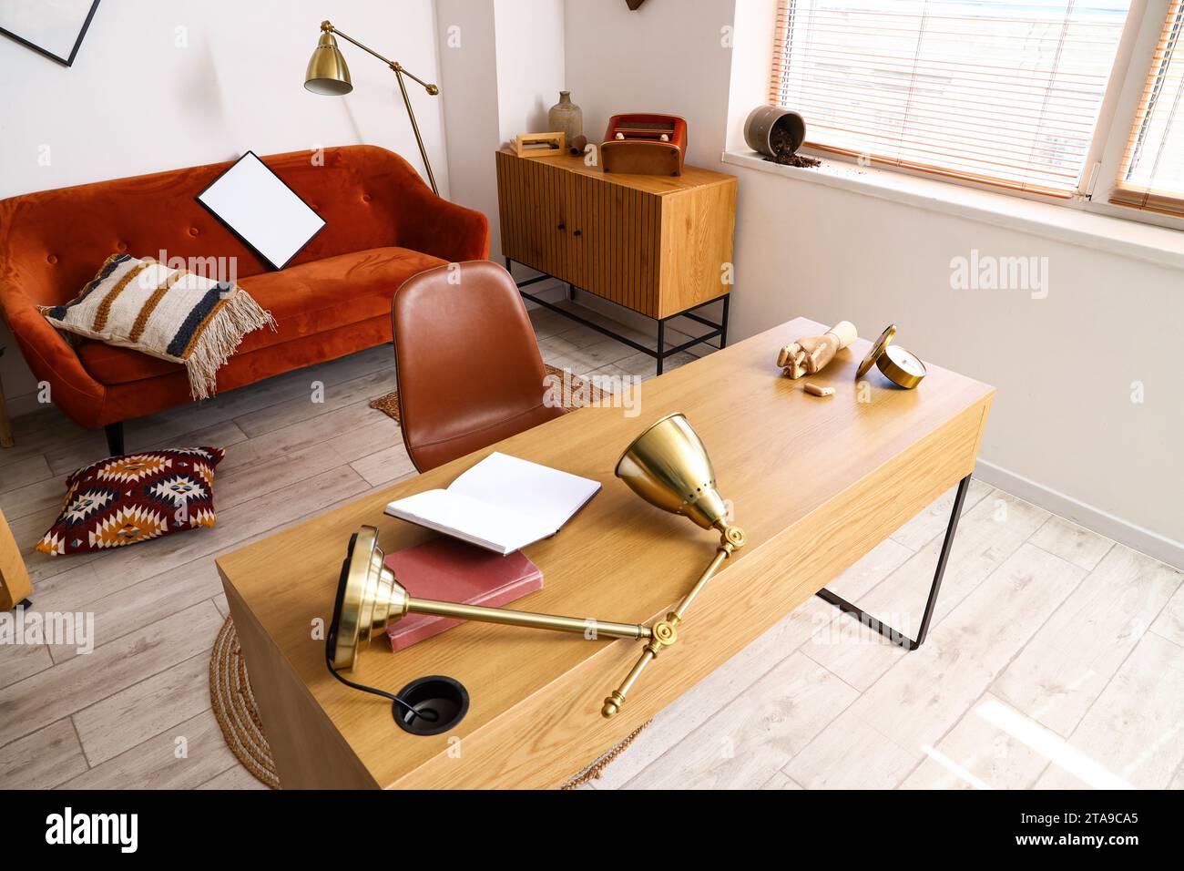 Modern workplace and sofa in messy office Stock Photo - Alamy