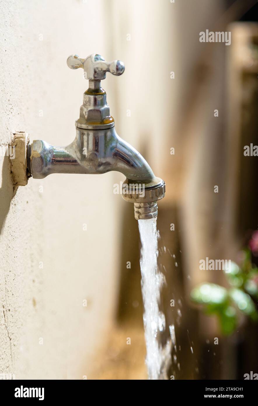 Open water tap in the backyard. Open faucet with water running. Waste ...