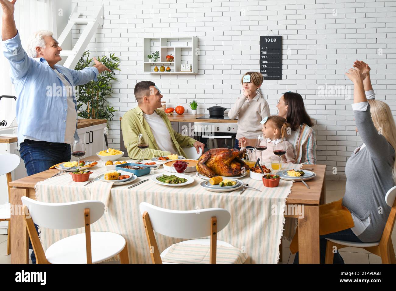 Happy family playing word guessing game at festive table on ...