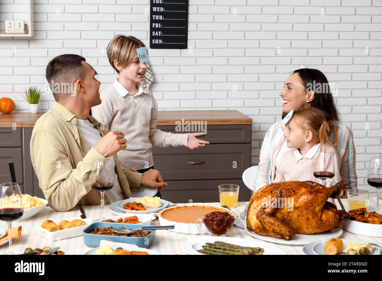 Happy family playing word guessing game at festive table on ...