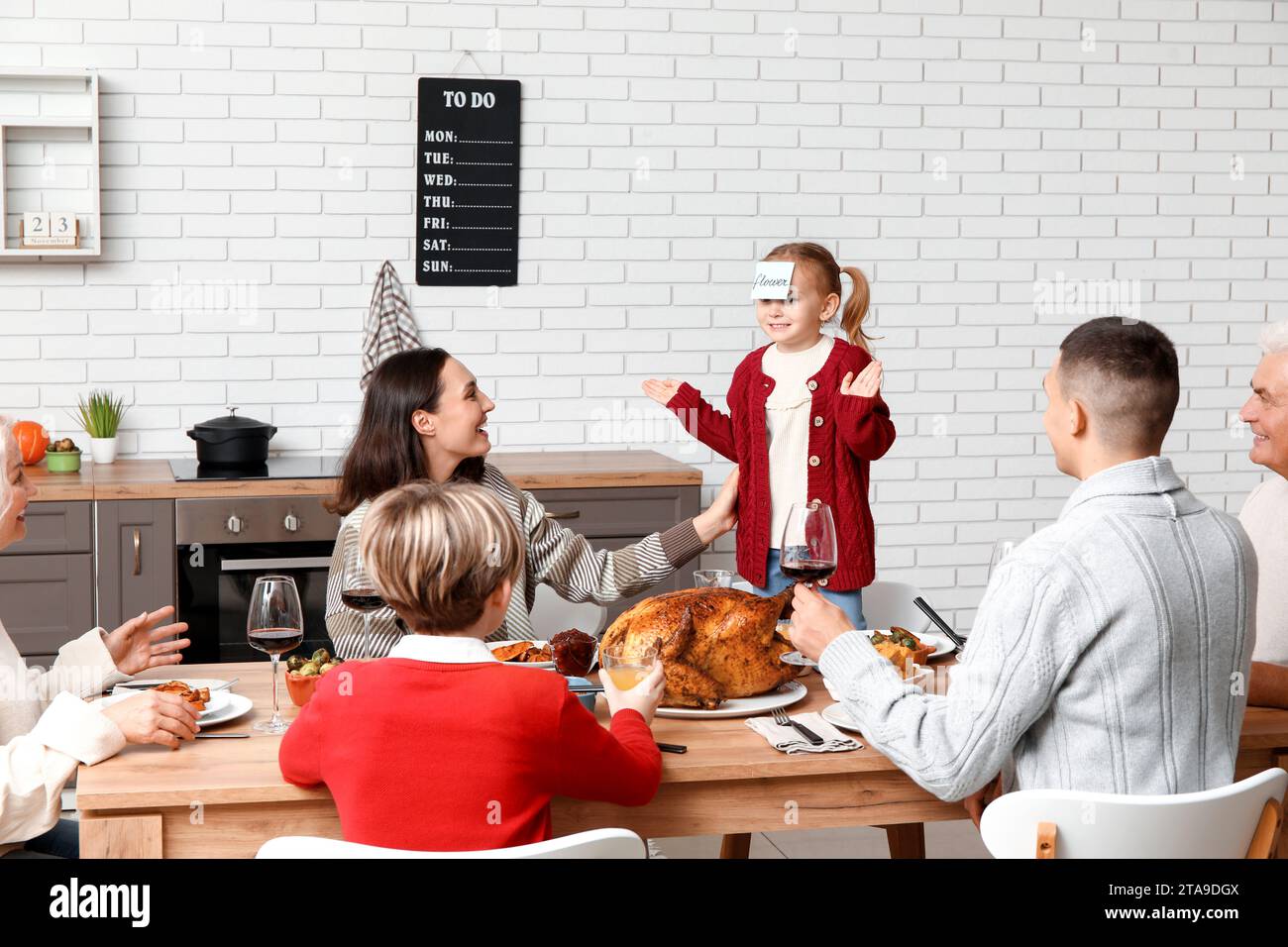 Happy family playing word guessing game at festive table on ...