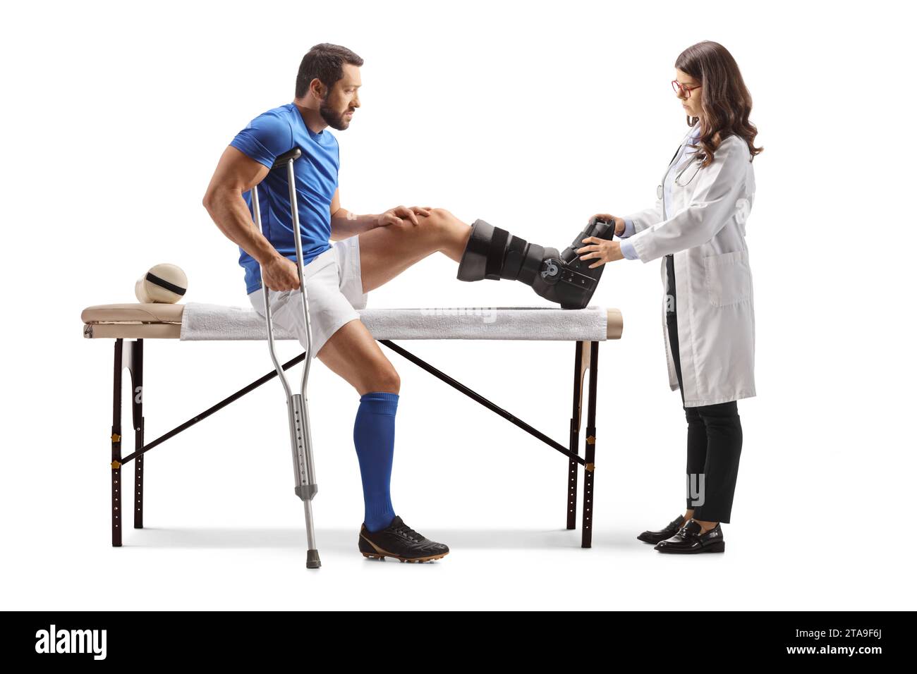 Doctor checking an injured football player with a foot brace isolated ...