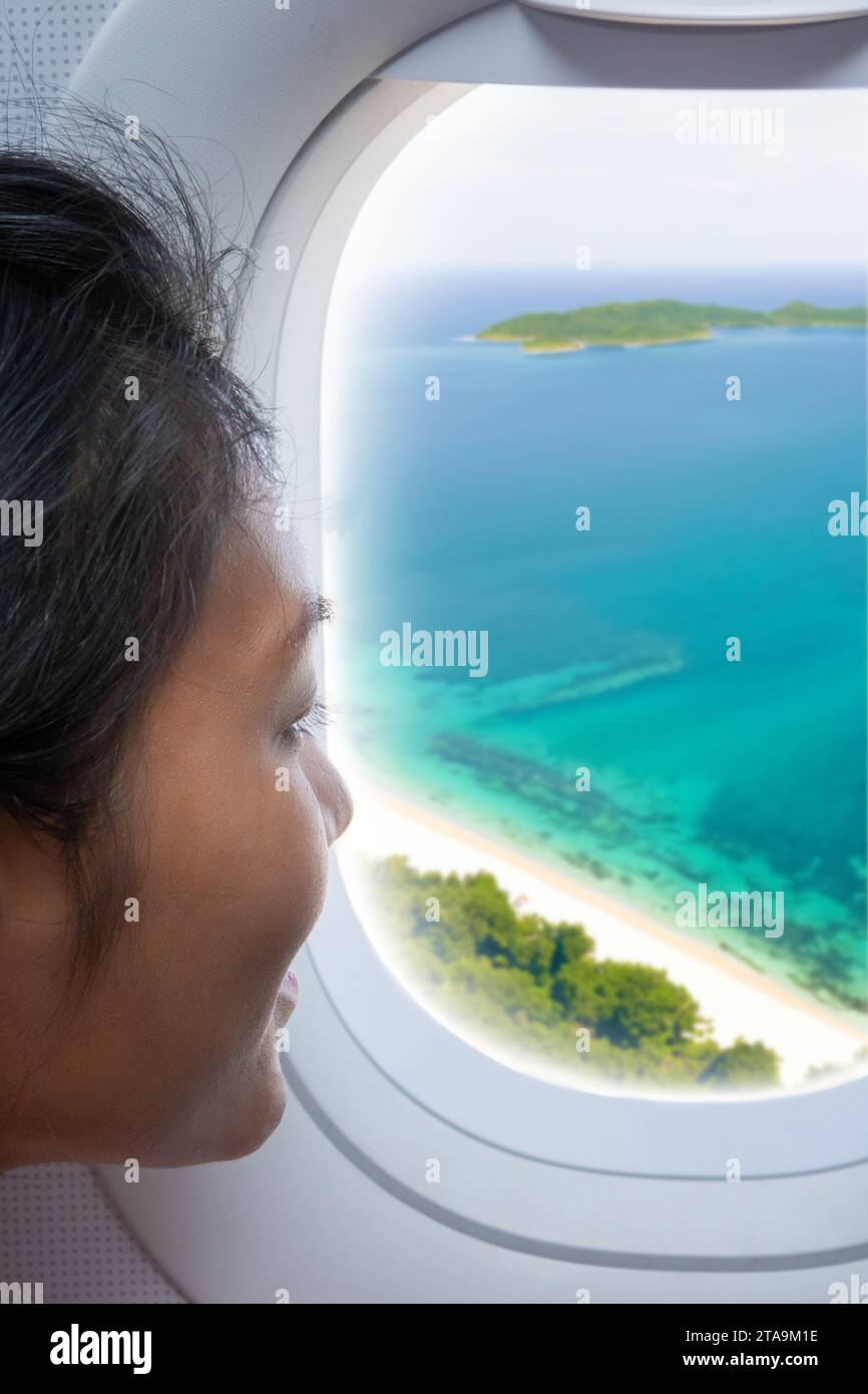 A young woman looks out of the window in a flying plane Stock Photo - Alamy