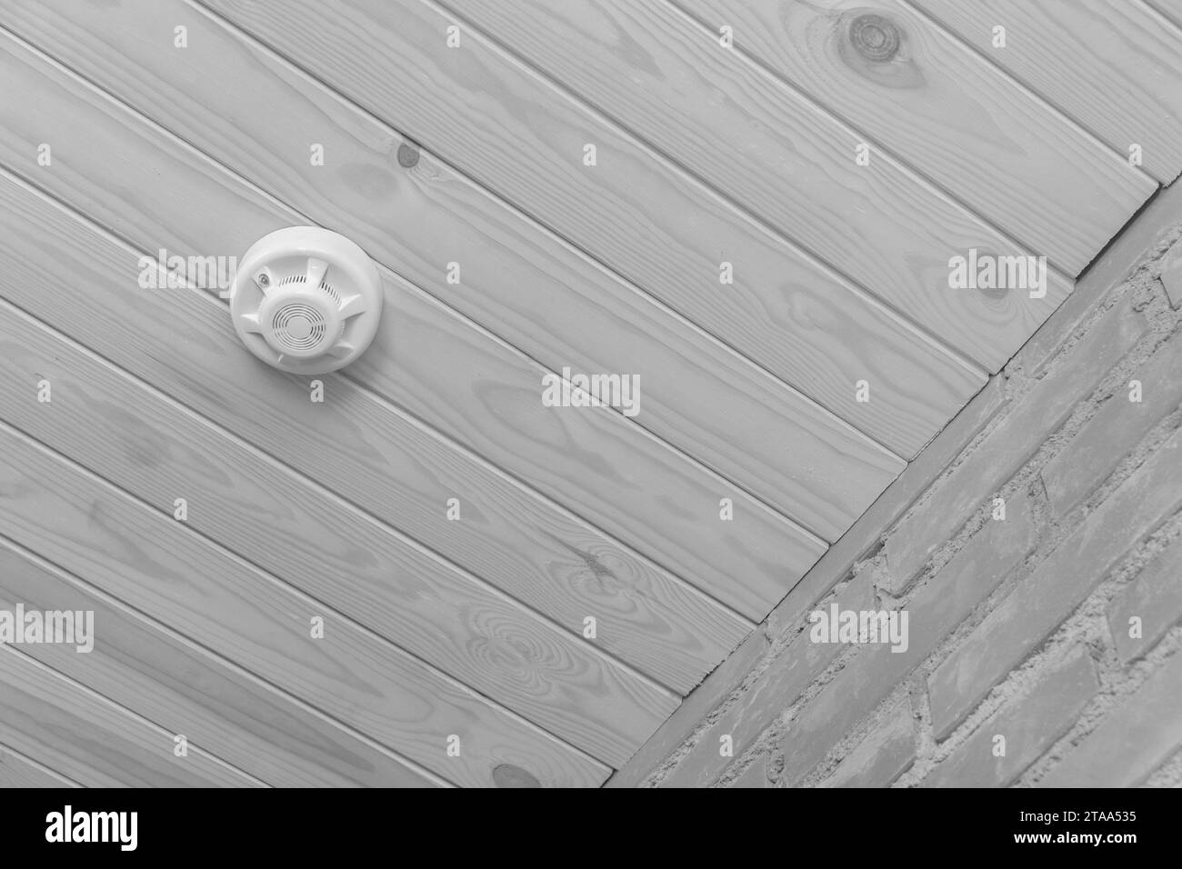 Fire alarm on wooden ceiling in grey interior smoke detector safety and ...