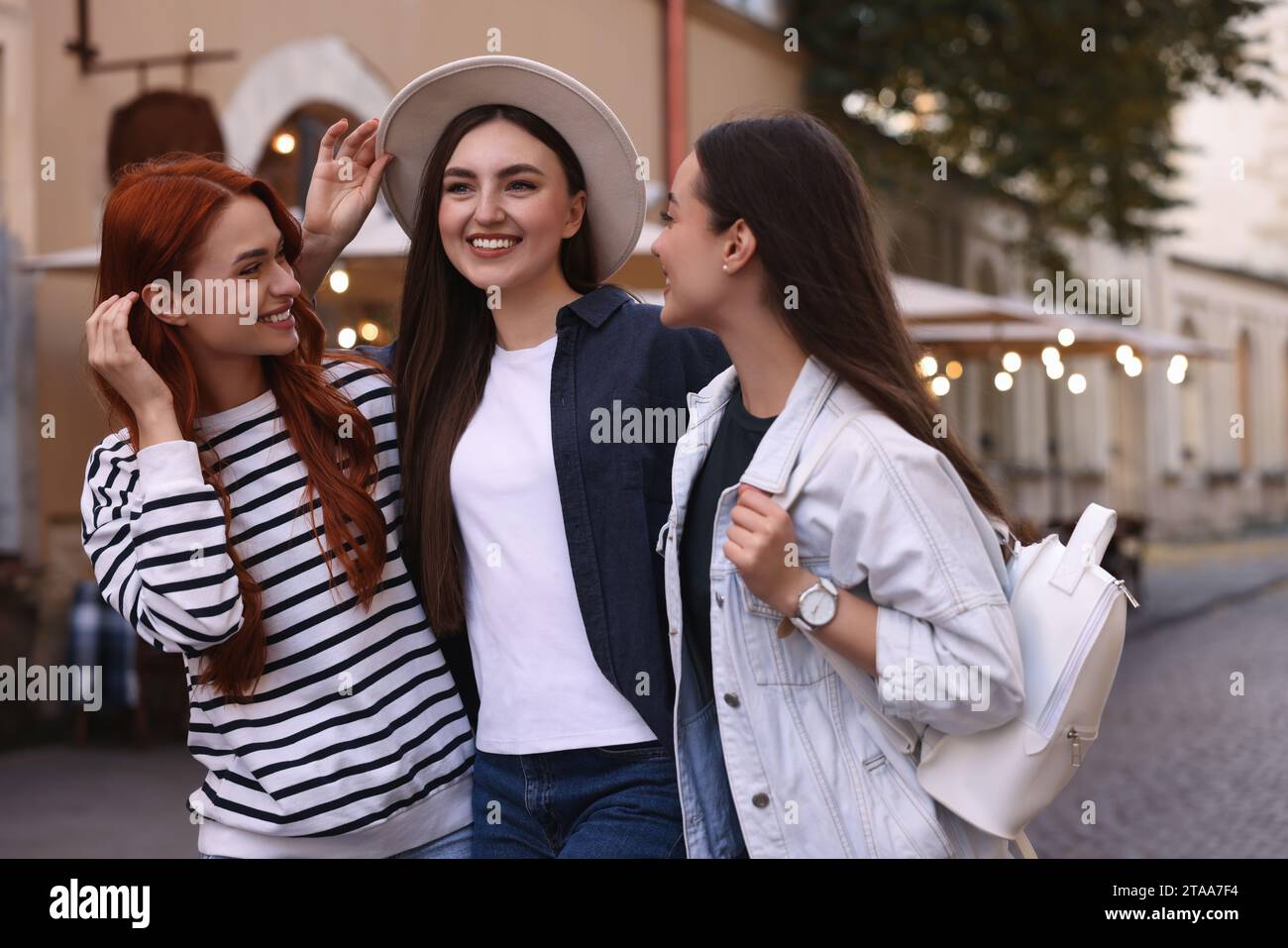 Happy friends spending time together on city street Stock Photo - Alamy