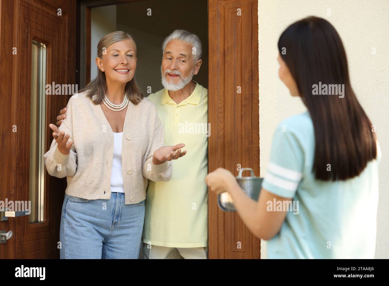 Friendly relationship with neighbours. Woman with saucepan visiting ...