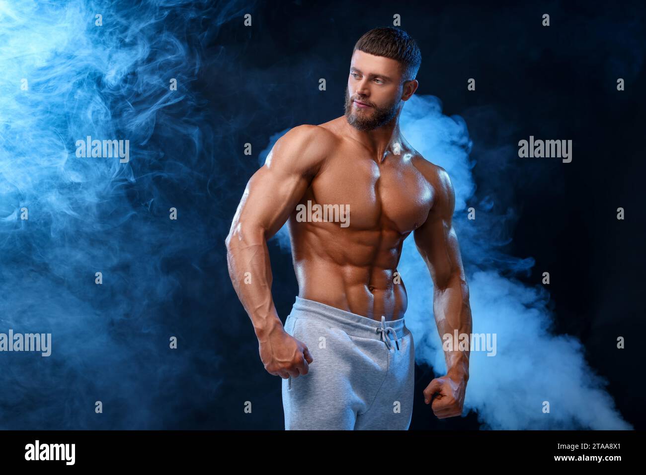 Young bodybuilder with muscular body in smoke on color background Stock ...