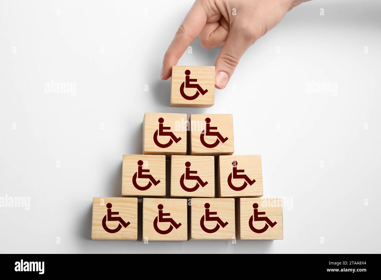 Inclusion concept. Woman building pyramid of wooden cubes with ...