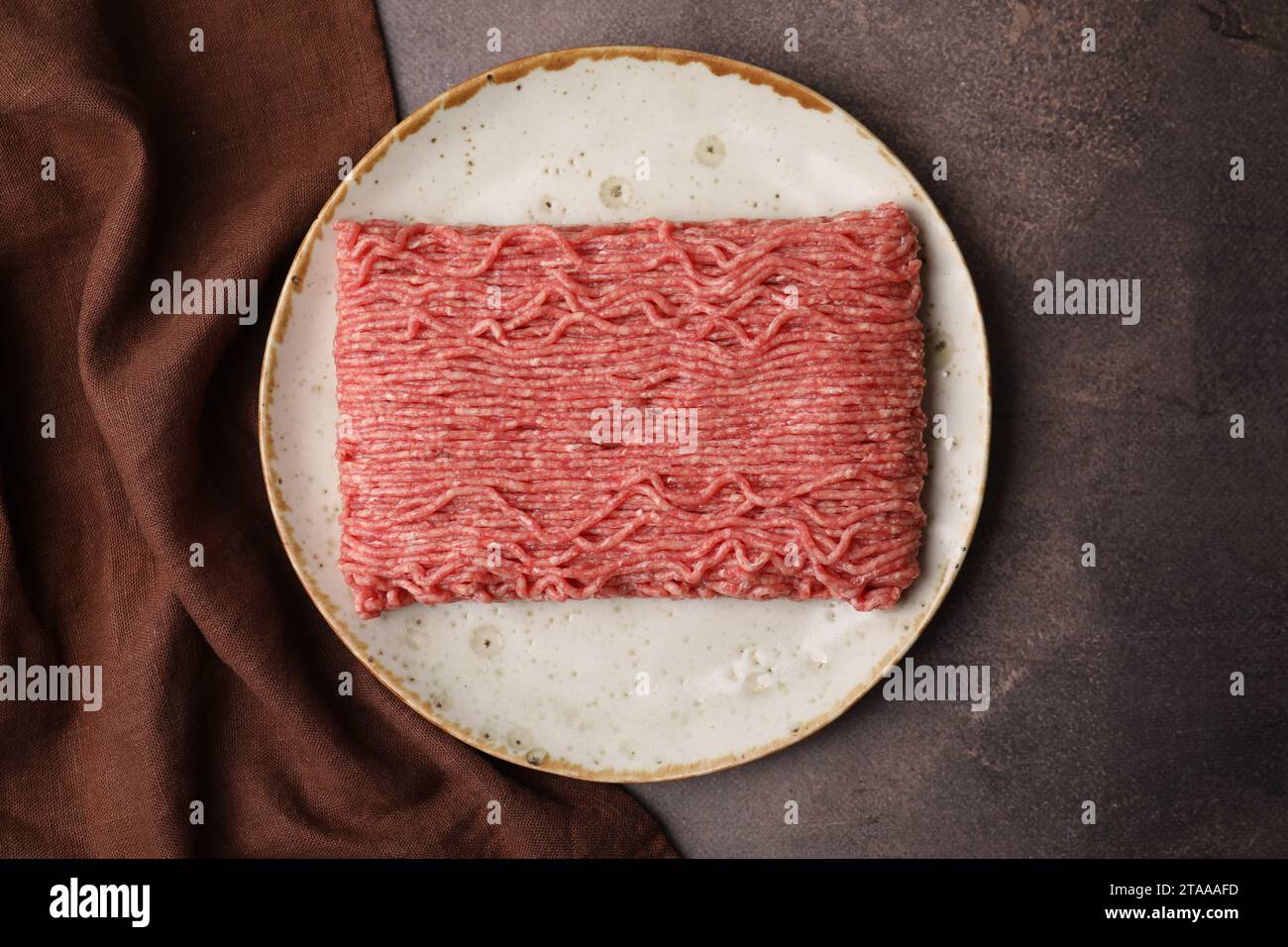 Fresh raw ground meat on brown textured table, top view Stock Photo - Alamy