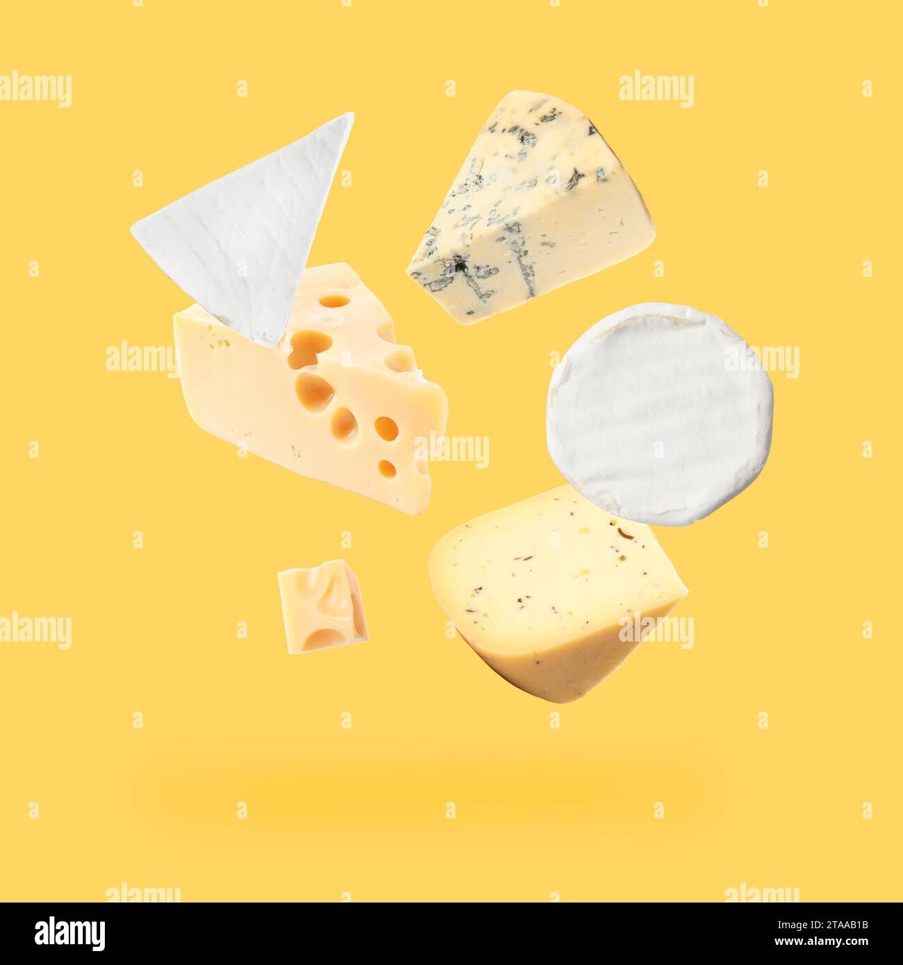 Different kinds of cheese falling on golden background Stock Photo - Alamy